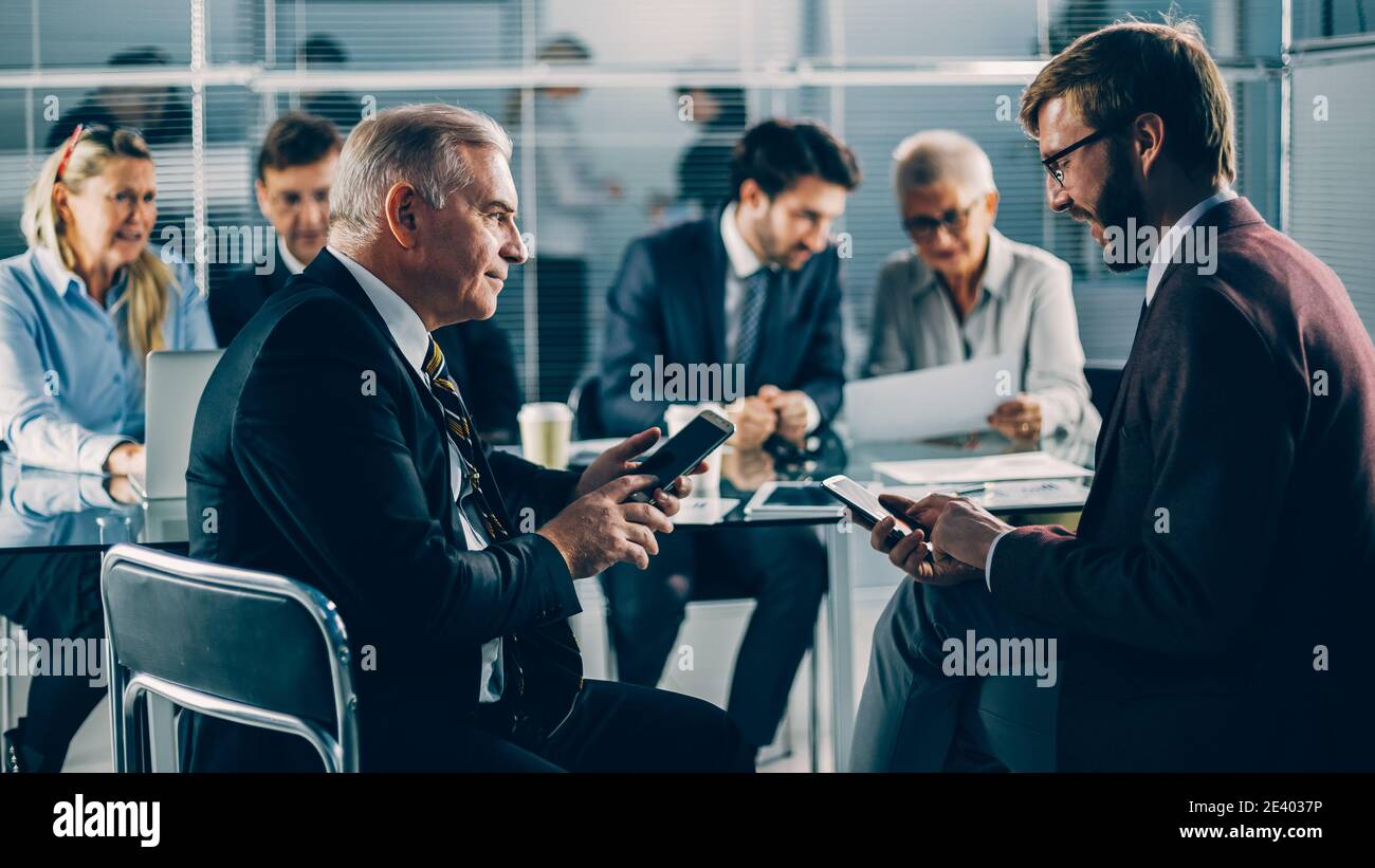 business colleagues using their smartphones during a work meeting Stock ...