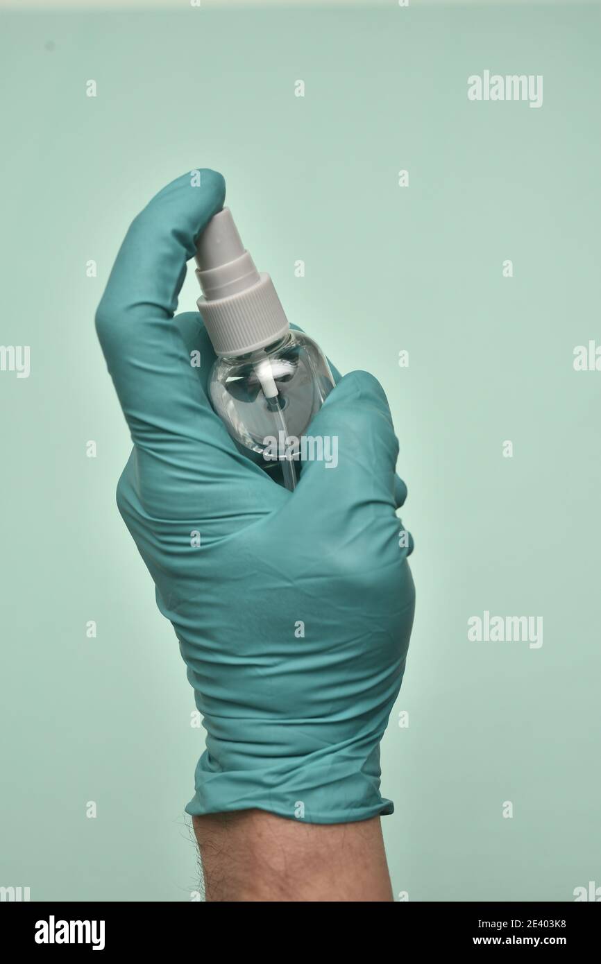 Vertical shot of a gloved hand holding a bottle of sanitizer Stock ...