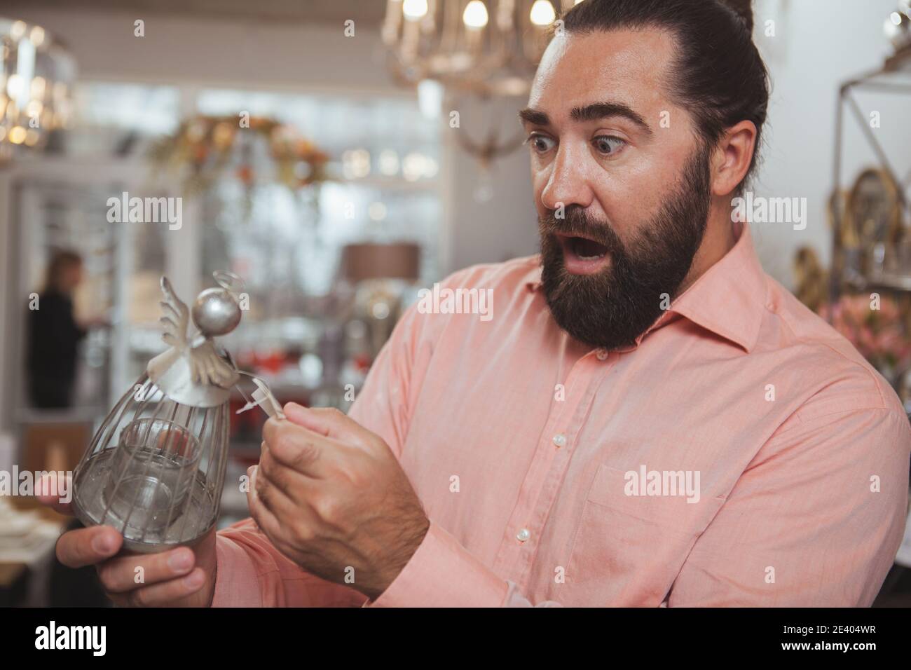 Mature bearded man looking overwhelmed, reading price tag, while ...