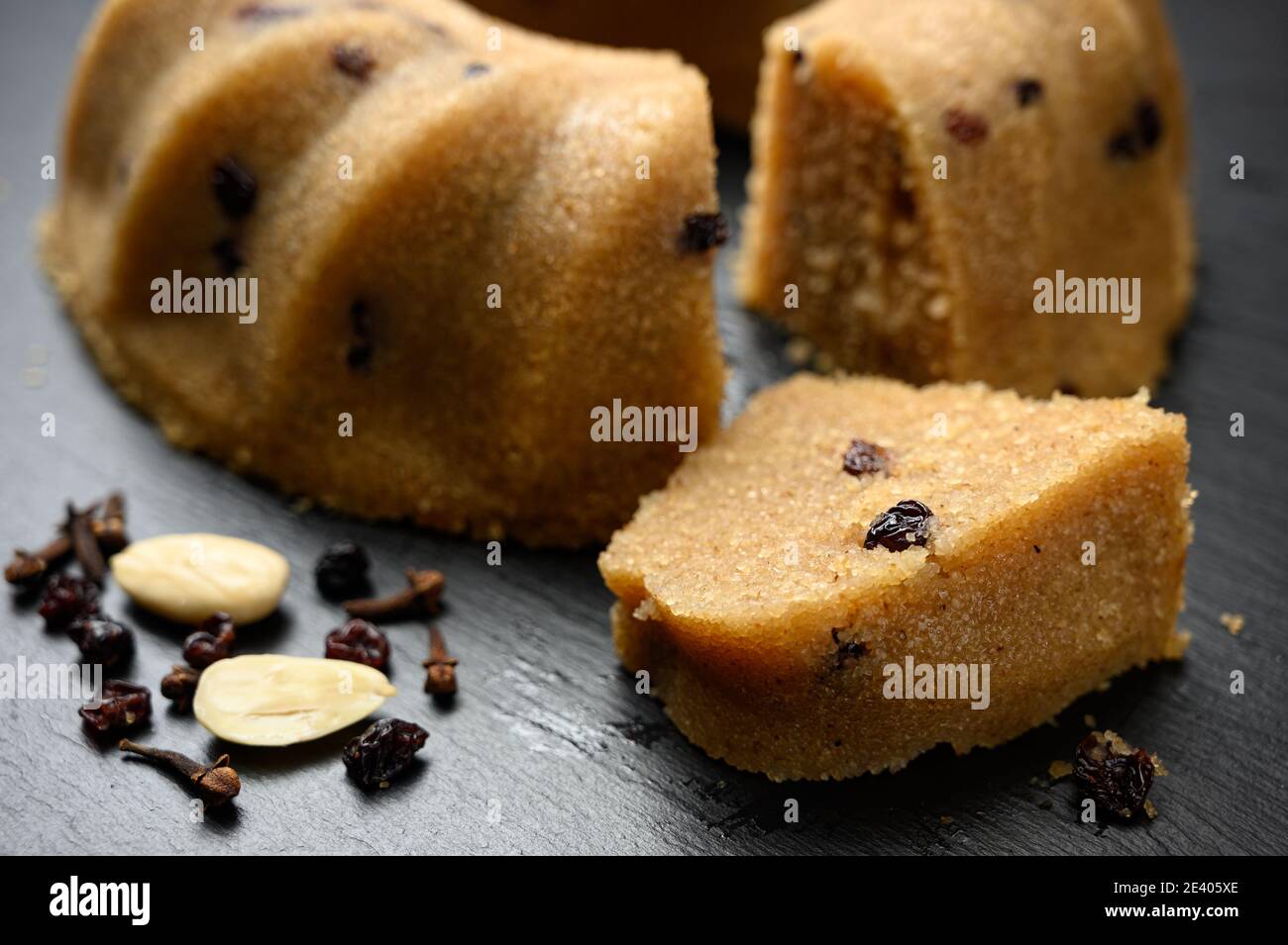 Homemade semolina halva with raisins served on black dish with nuts ...