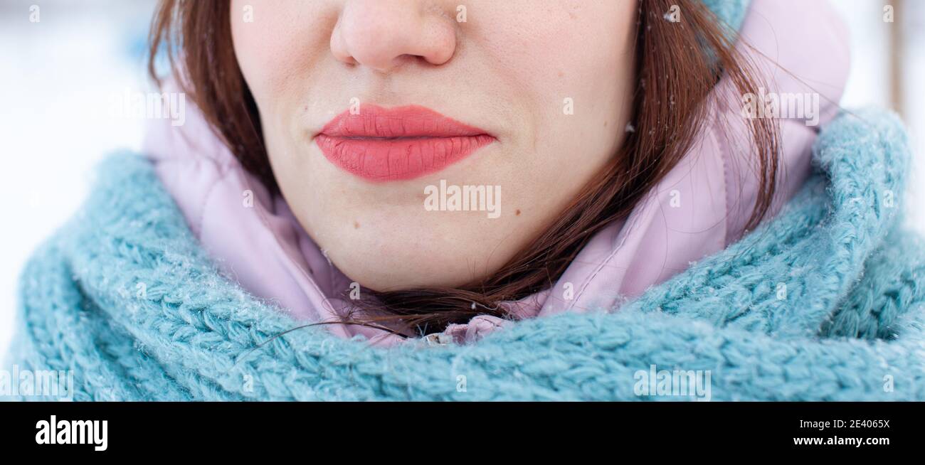 The girl has braces on her teeth. A girl in the winter on the street ...