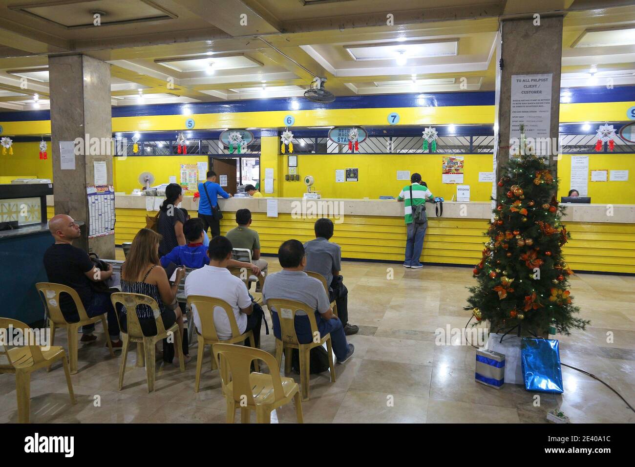 MANILA, PHILIPPINES - DECEMBER 7, 2017: People wait at the post office ...
