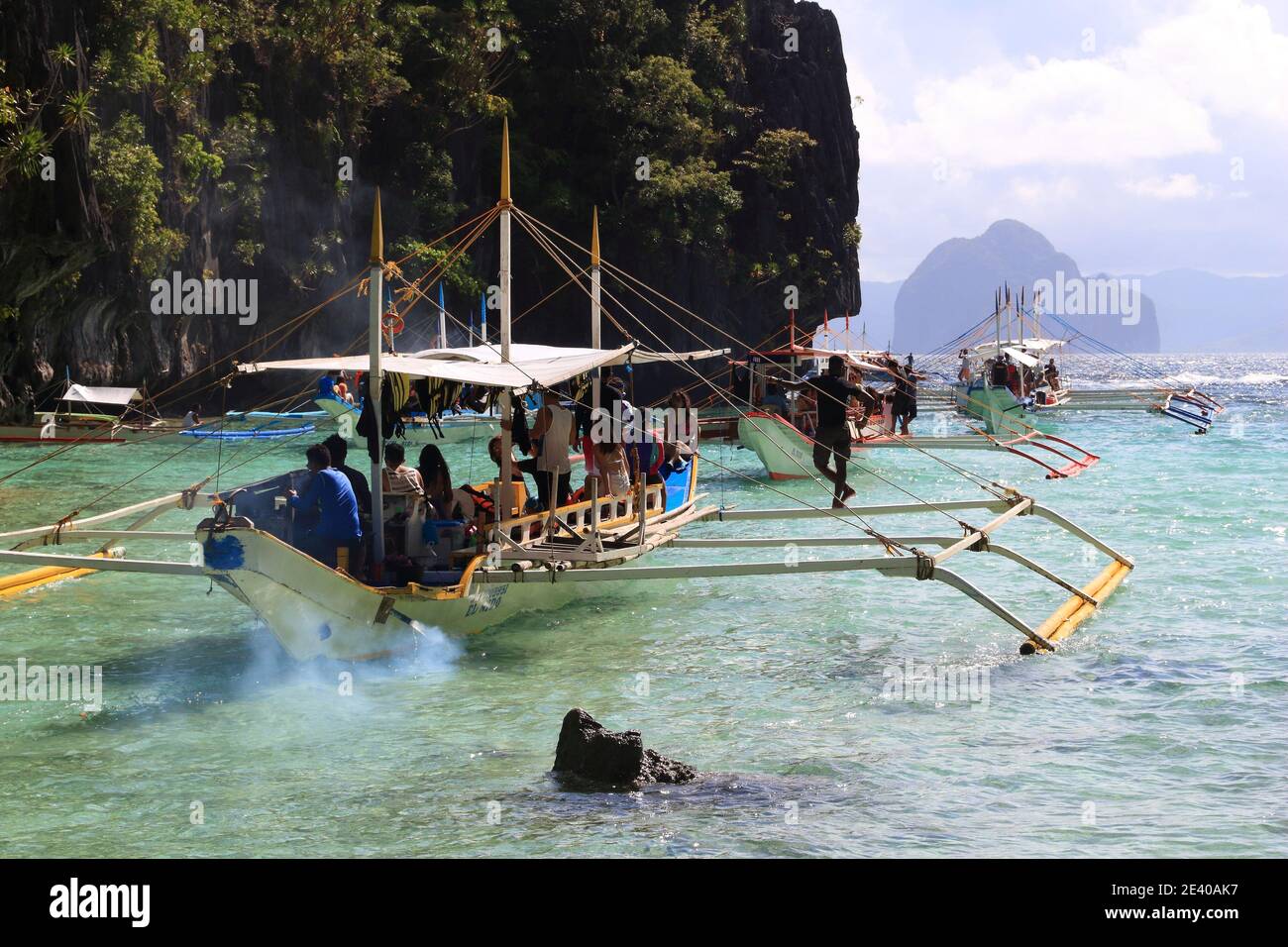 PALAWAN, PHILIPPINES - DECEMBER 1, 2017: People ride outrigger bangka ...