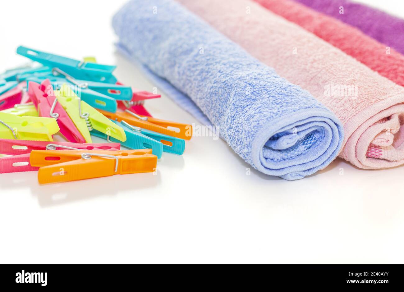 Clean and wrapped towels and many plastic clothespins on a white ...