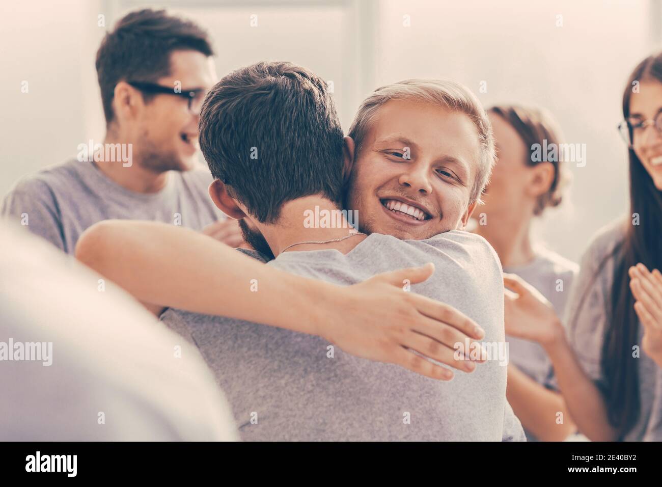 close up. happy contestants hugging each other Stock Photo - Alamy