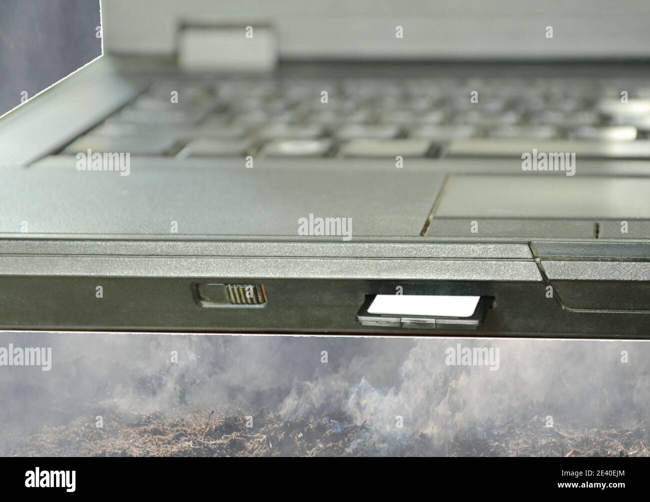 computer laptop in smoking from fire burning on ground background with ...