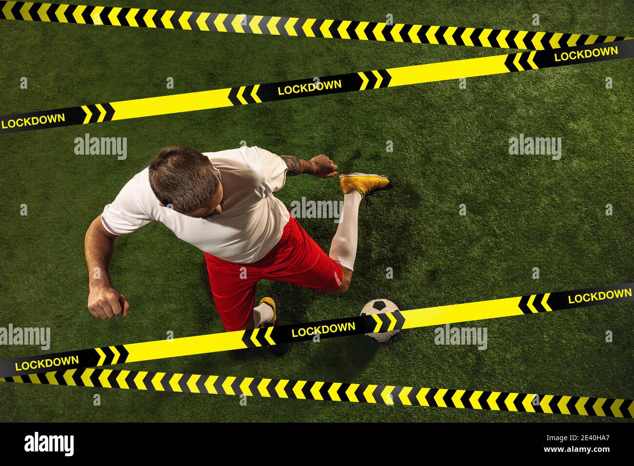 Football or soccer player on grass background behind limiting tapes ...