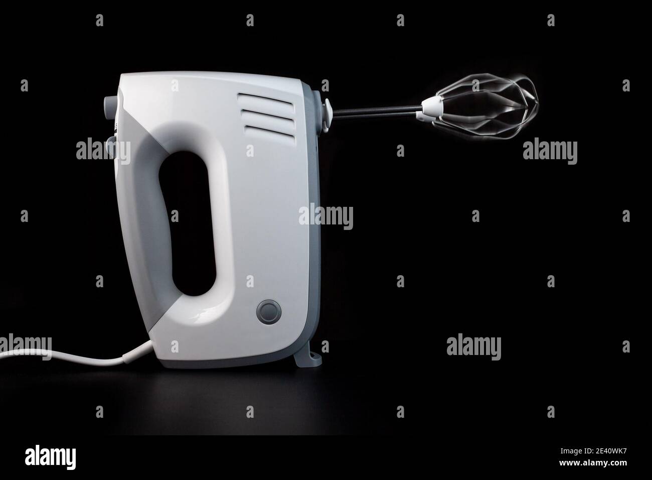 Side view on working hand mixer with stirring whisks rotate on high ...