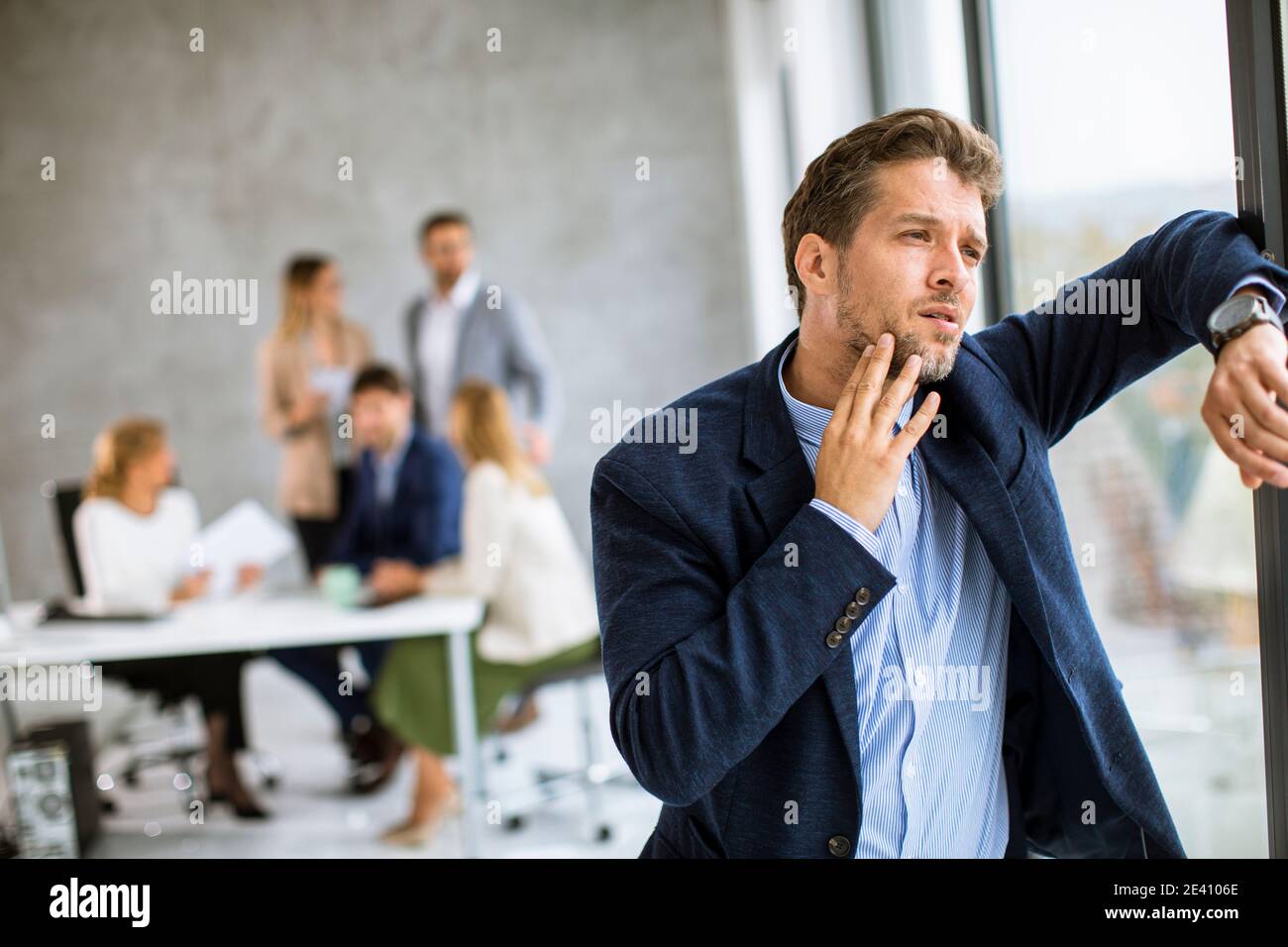 Young business man feeling exhausted and stand at his working place in ...