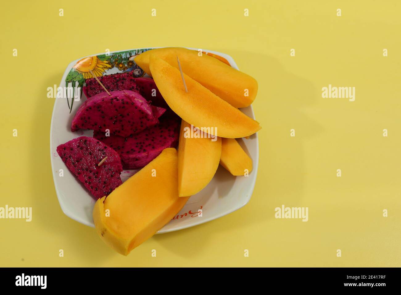 Top view of a plate of fresh ripe mango and dragon fruit slices ...