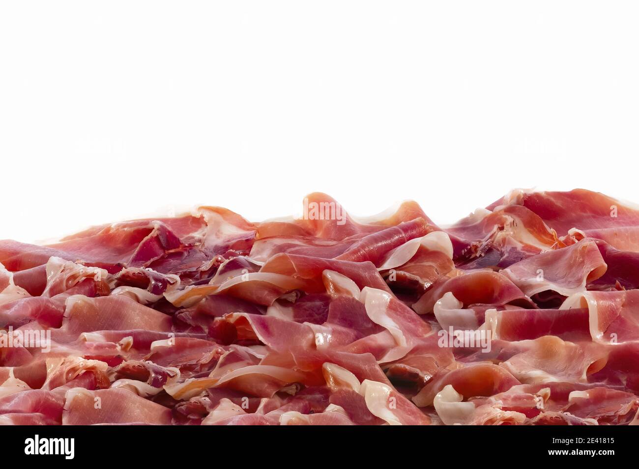 Heap of slices of typical Spanish ham on a white background with space ...