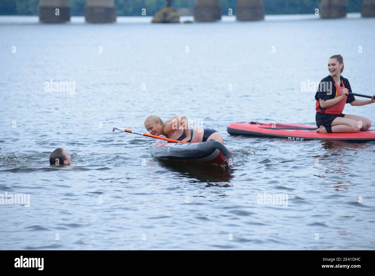 An old woman fell down off the SUP board into water, young girl helping ...
