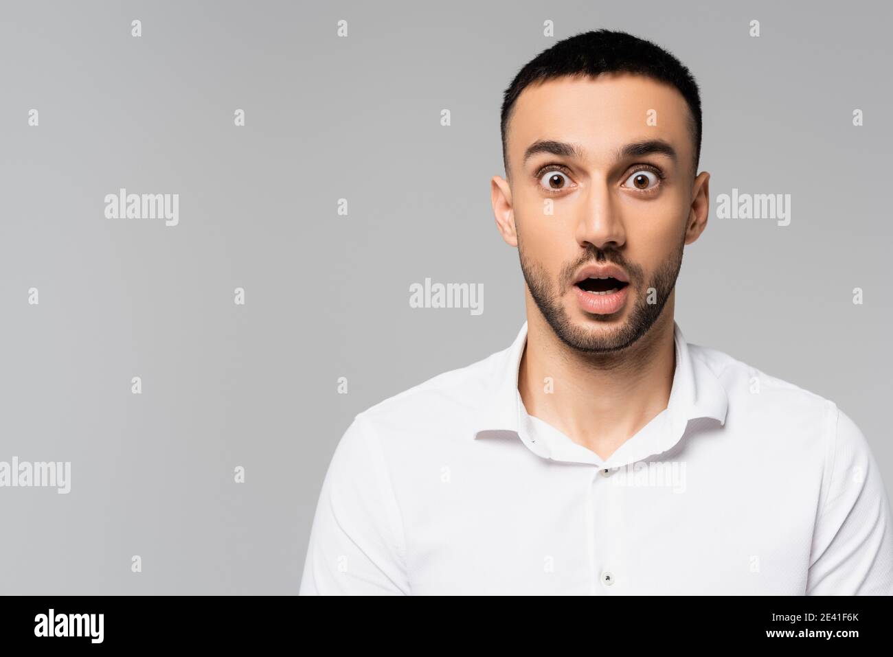 amazed hispanic manager with open mouth and bulging eyes looking at ...