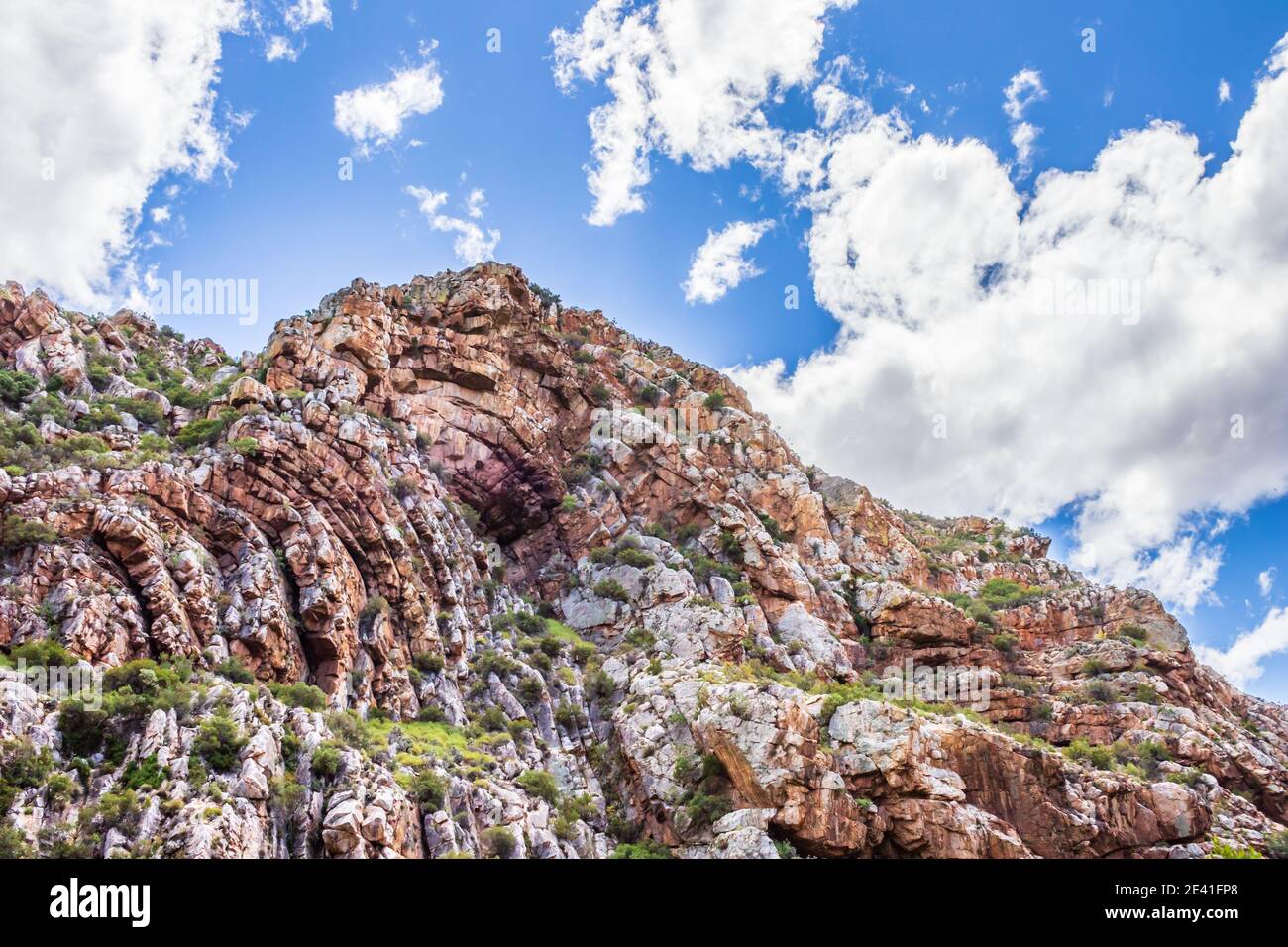 View of a Mountain range with large red rocky outcrops covered with ...
