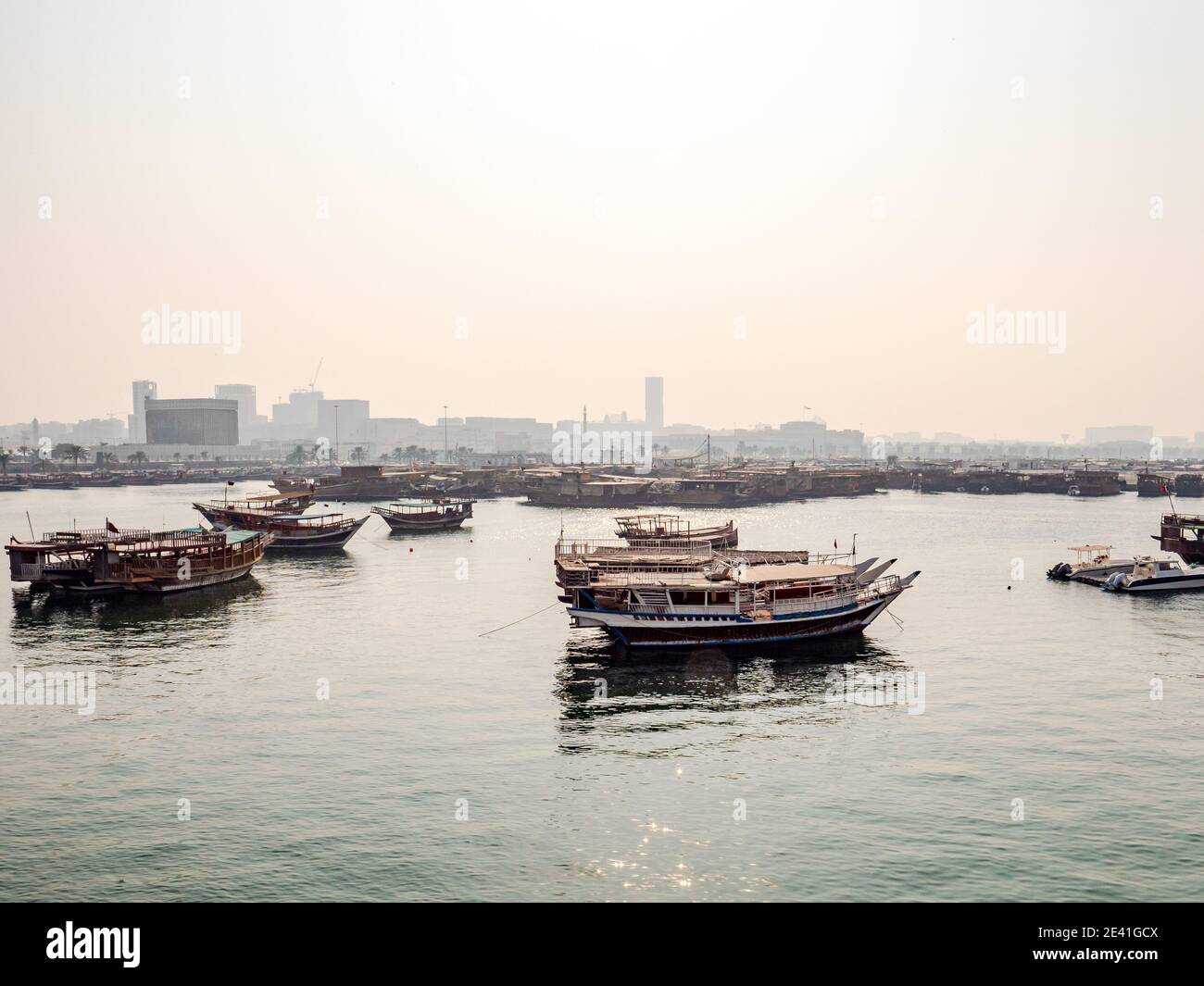 Traditional dhow boats moored in the port near Museum of Islamic Art ...
