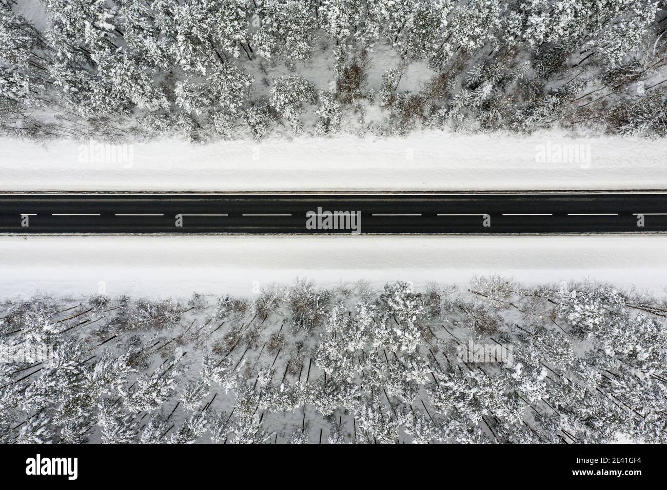 country road going through the beautiful snow covered landscapes ...