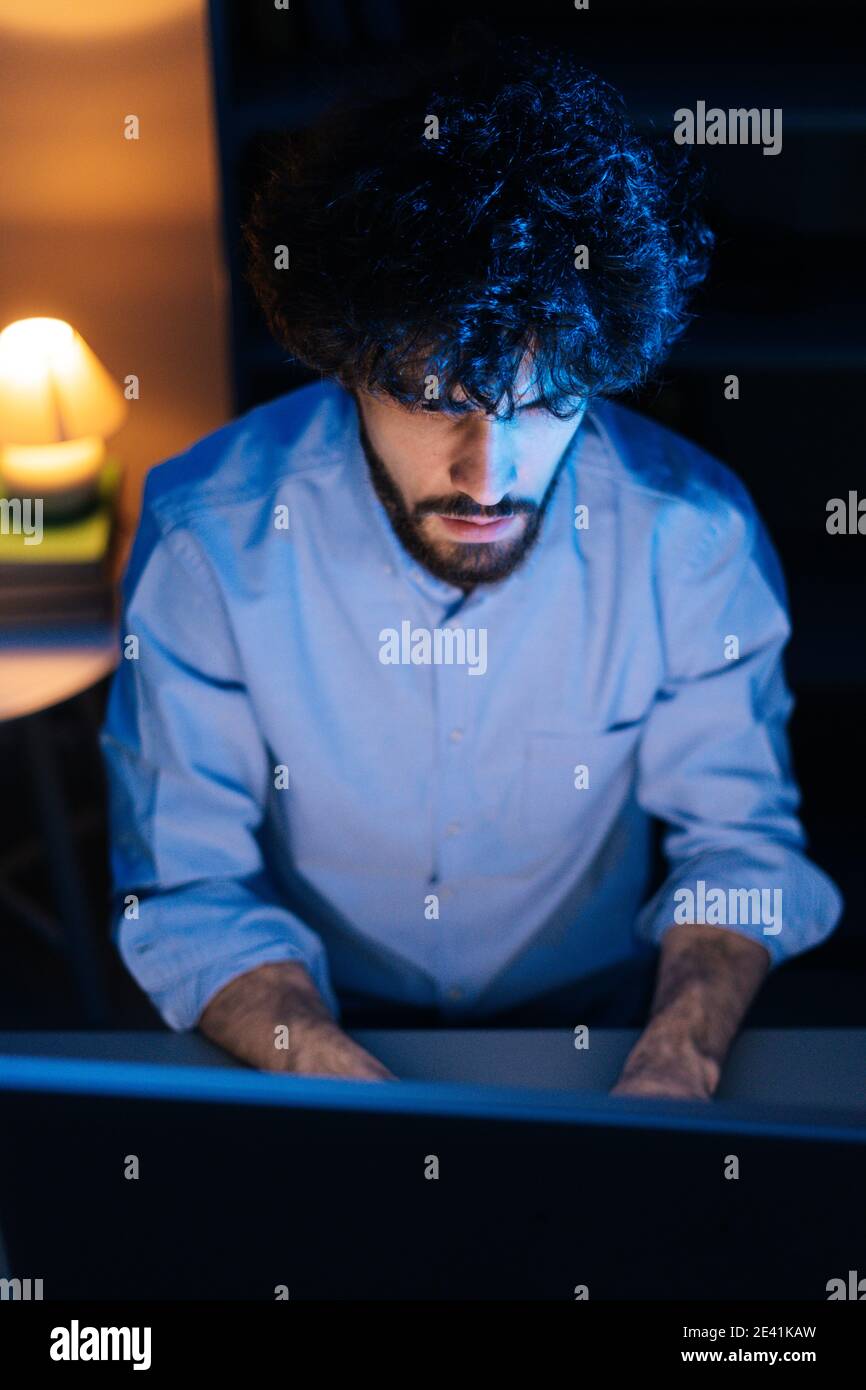 Top view of young man watching on monitor screen and working on ...