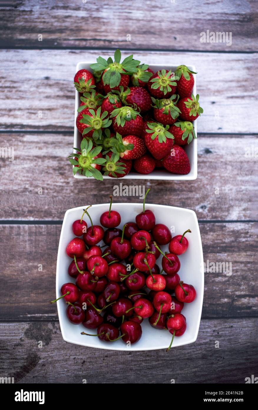 Top view of fresh strawberries and cherries in a white dessert bowl ...