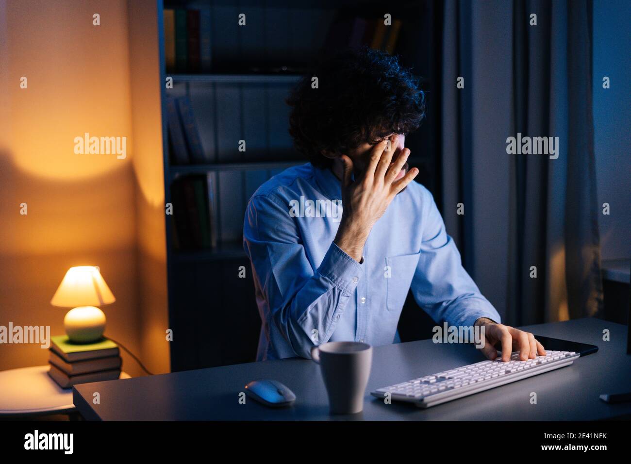 Tired young man working using computer then puts his head on keyboard ... Tired young man working using computer then puts his head on keyboard ...