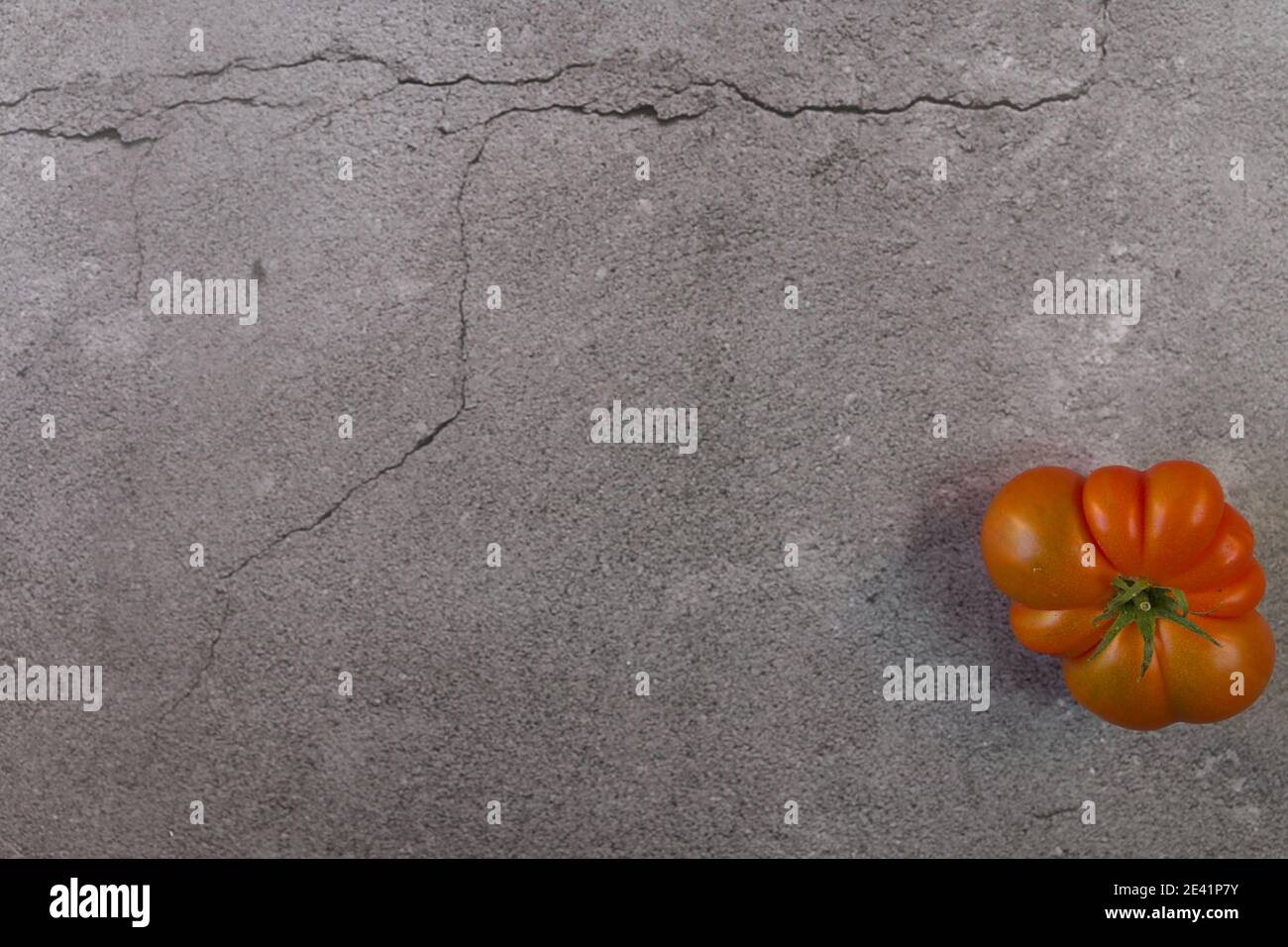 Top view of ripe tomato on a cracked concrete surface Stock Photo - Alamy