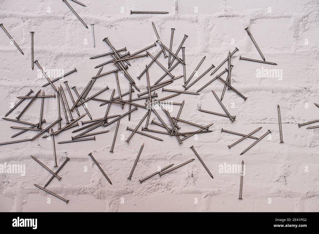 Top view of concrete nails on a white brick wall surface Stock Photo ...