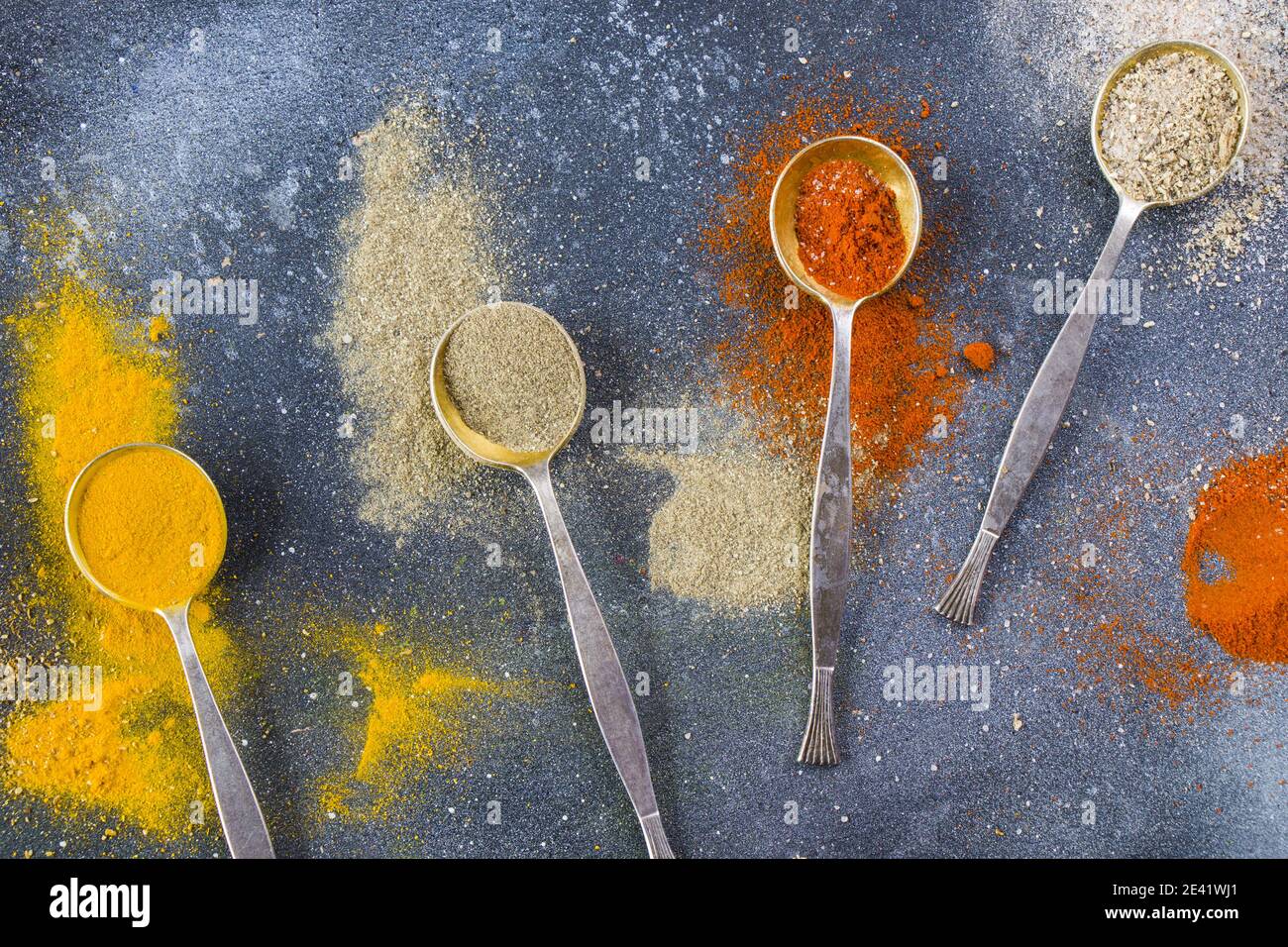 Top view closeup of the variety of spices on the vintage silver spoons ...