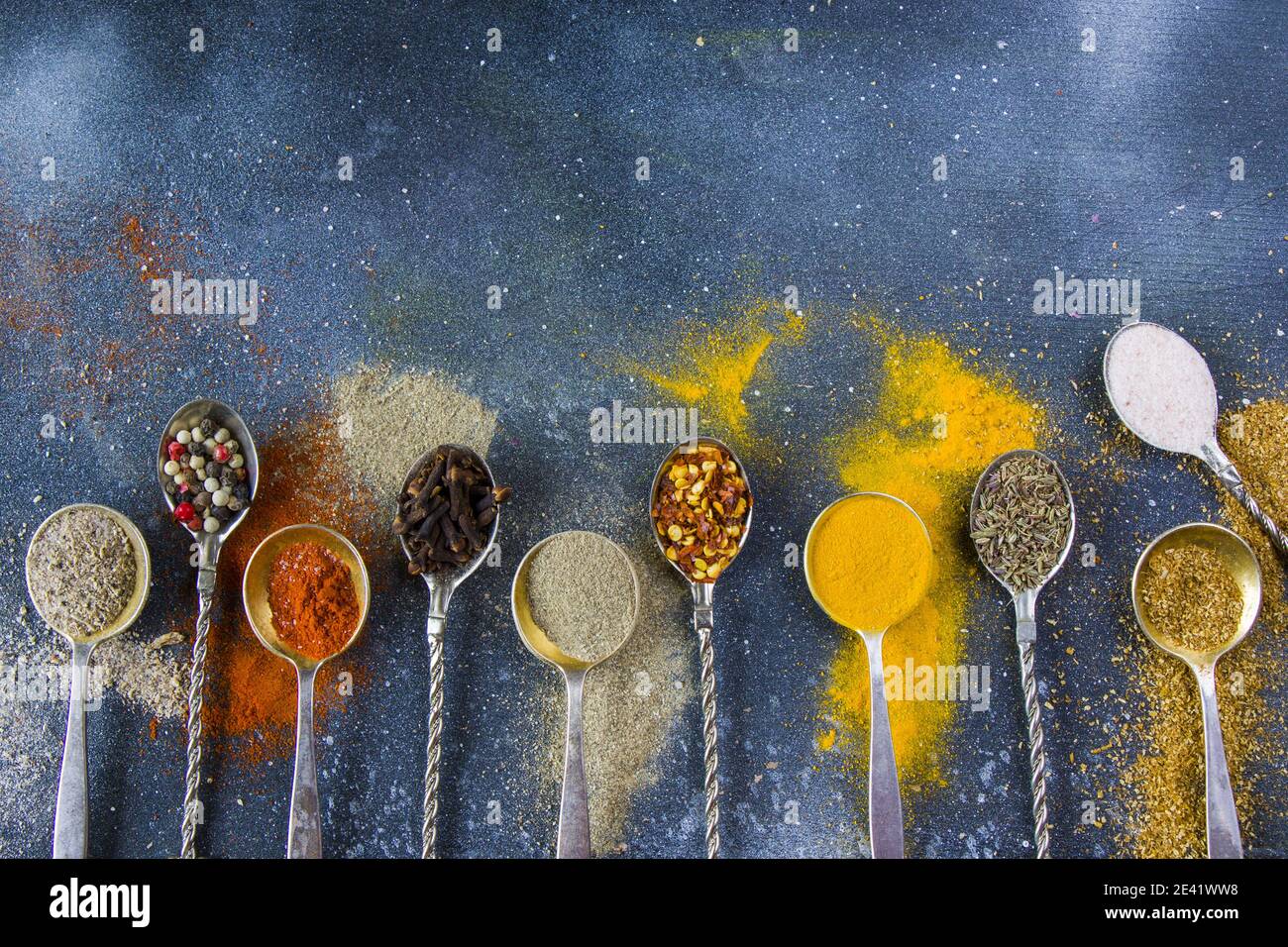 Top view closeup of the variety of spices on the vintage silver spoons ...