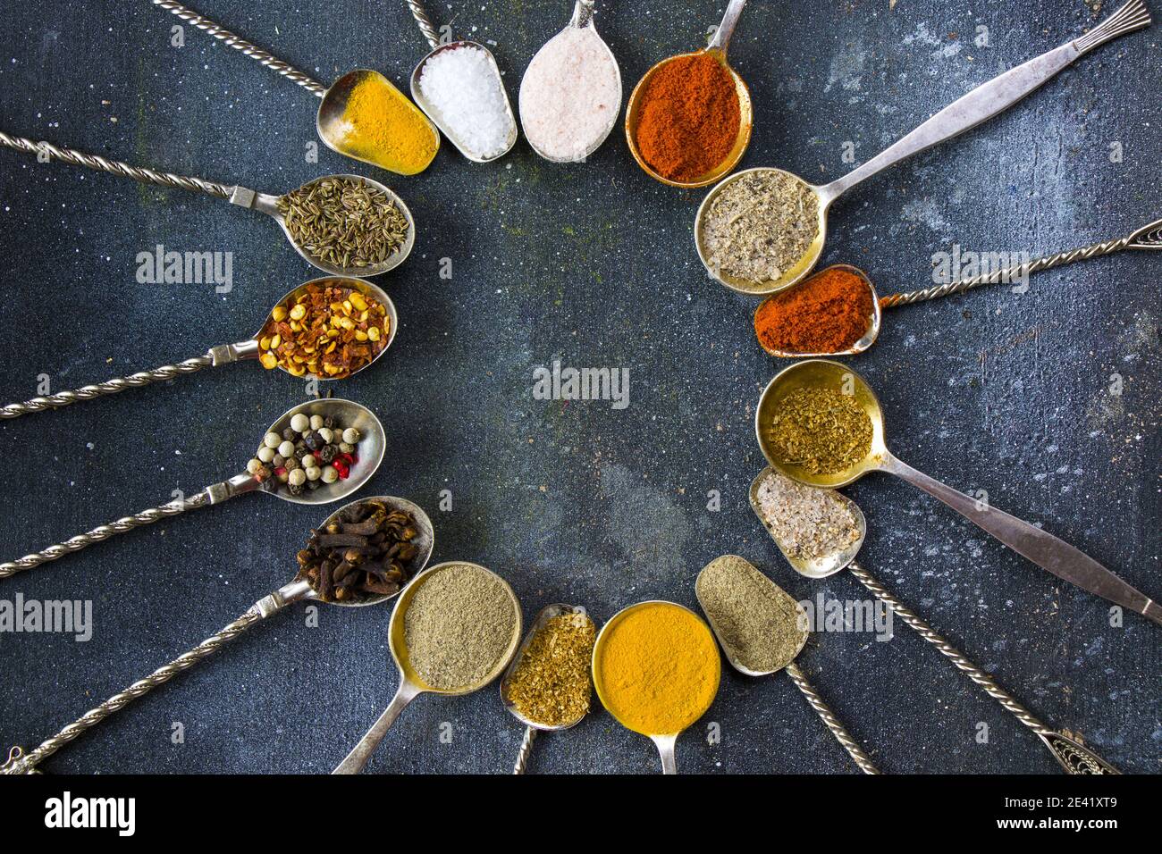 Top view closeup of the variety of spices on the vintage silver spoons ...