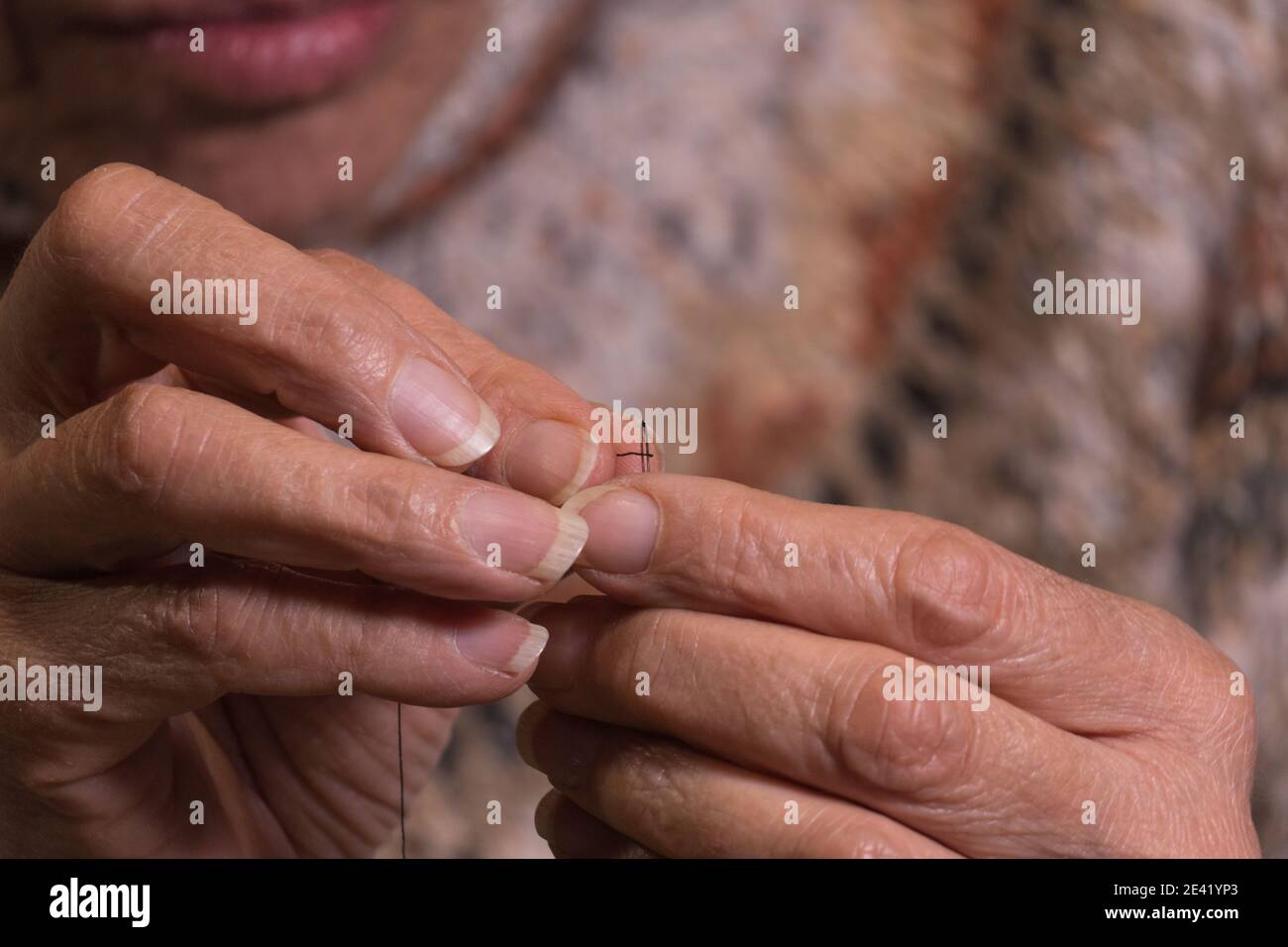 Hands threading a needle Stock Photo - Alamy