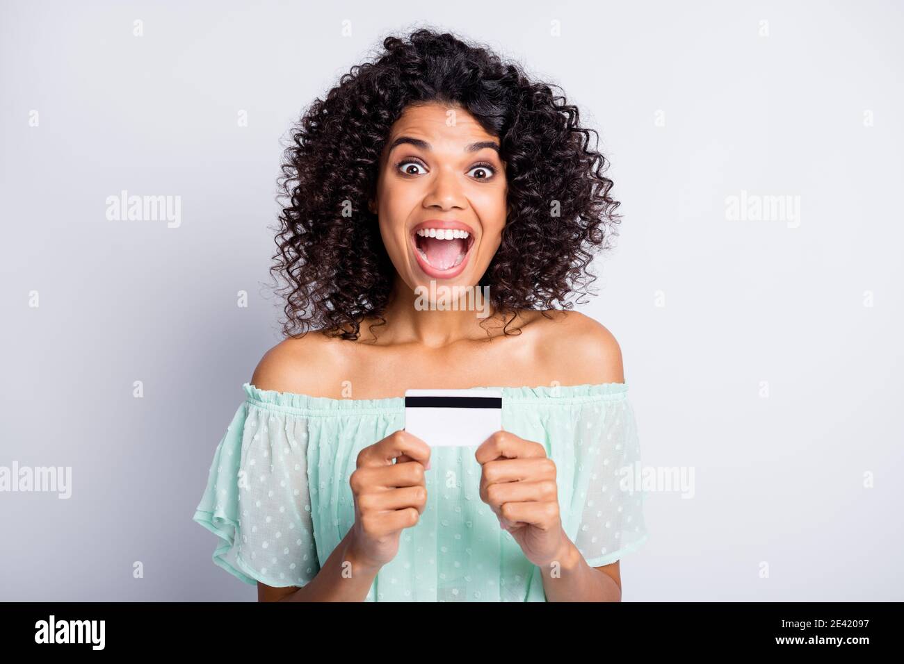 Photo portrait of screaming girl holding credit card in two hands ...