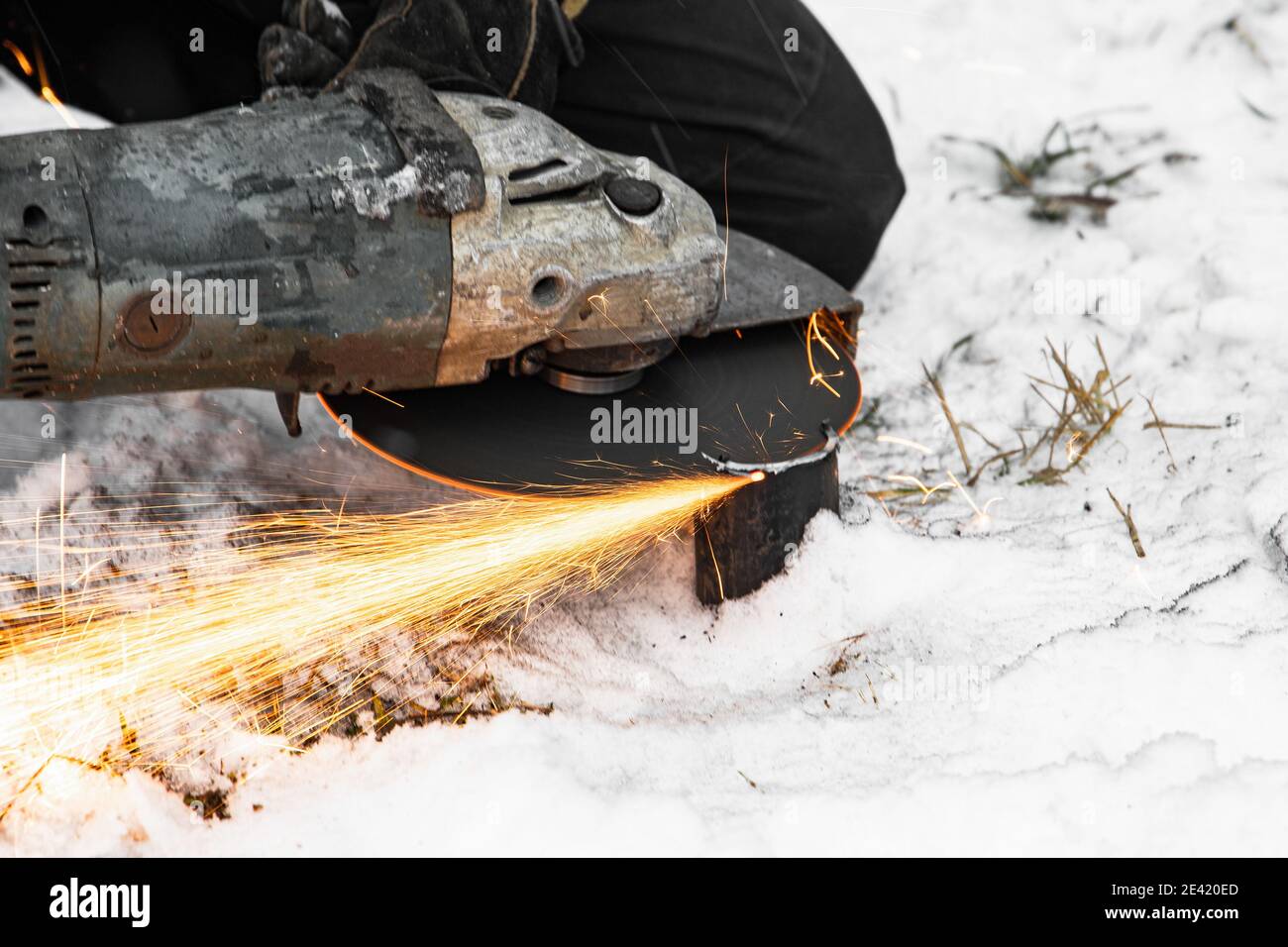 Angle grinder works with sparks over white snow, close up photo Stock ...