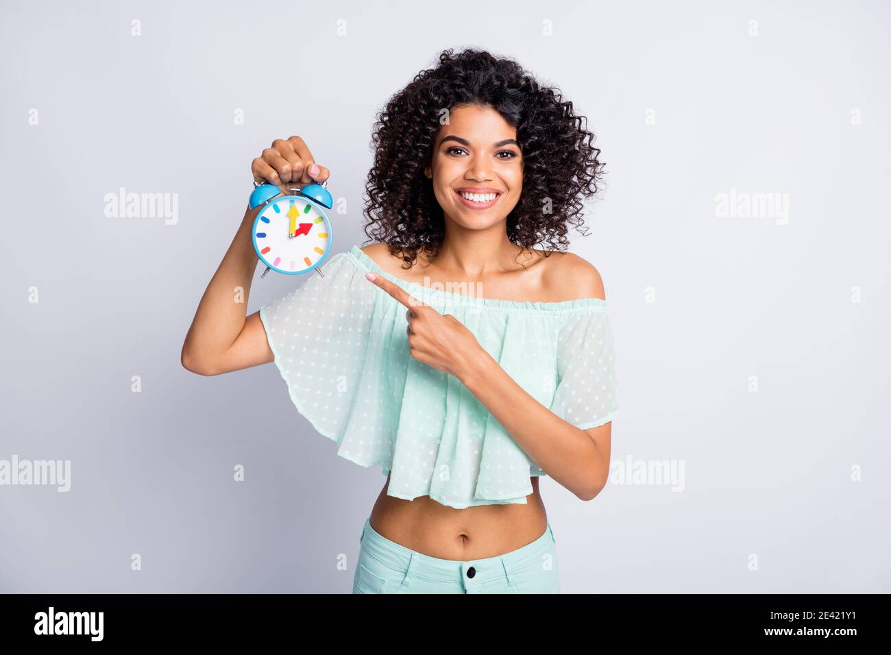 Photo portrait of girl pointing finger holding clock in one hand ...
