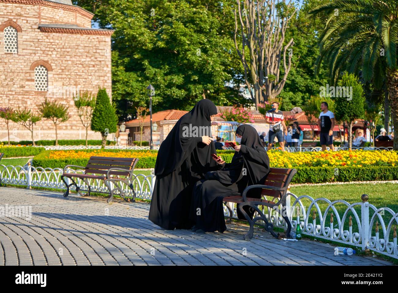 Two muslim women in hijab relaxing on the bench next to Sofia mosque ...