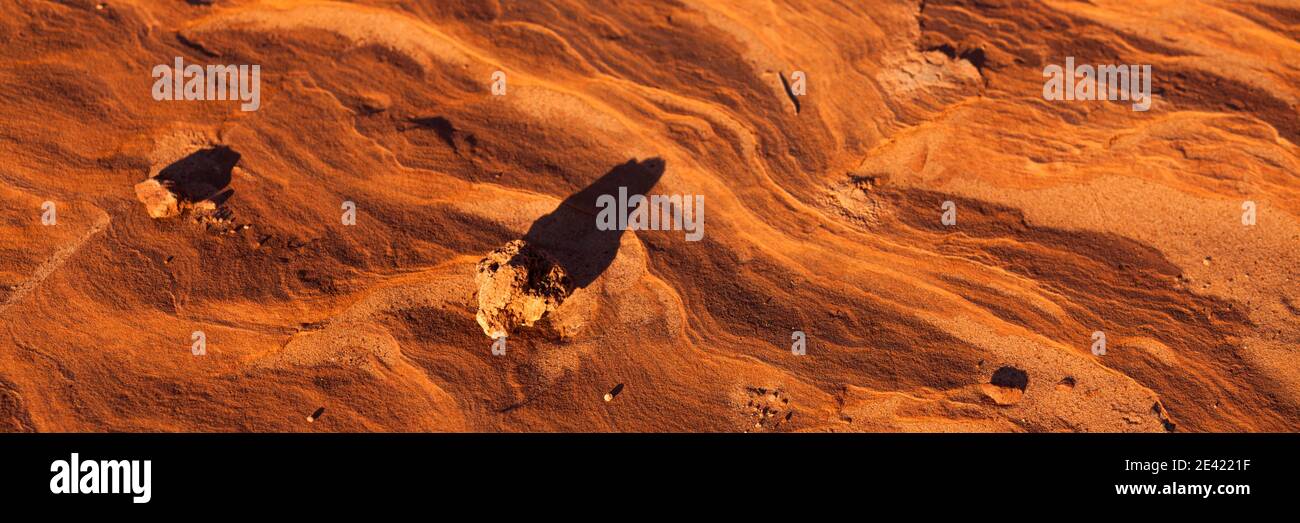 Late afternoon sunshine creating long shadows on small pebbles resting ...