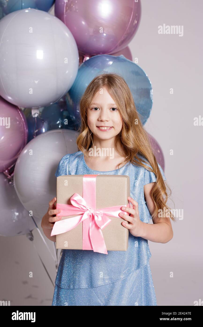 happy girl in studio with air balloons and gift box over white ...