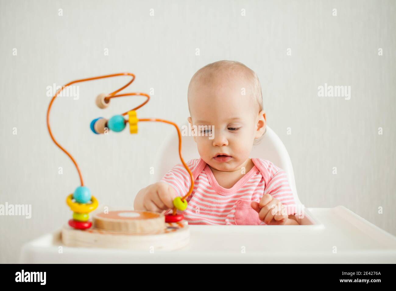 little girl plays with an educational maze toy. Development of fine ...
