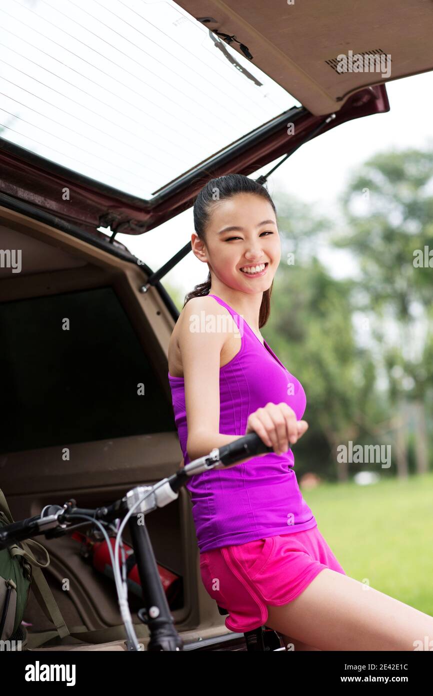 The young women taking the bicycle into the back of a car high quality ...