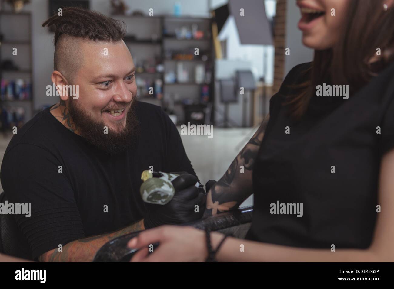 Bearded tattoo artist laughing looking evil, enjoying doing painful ...