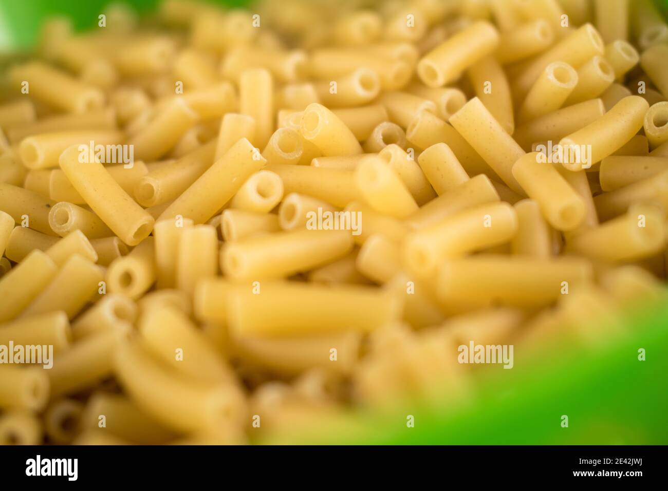 Close up of some raw macaroni in a green pot Stock Photo - Alamy
