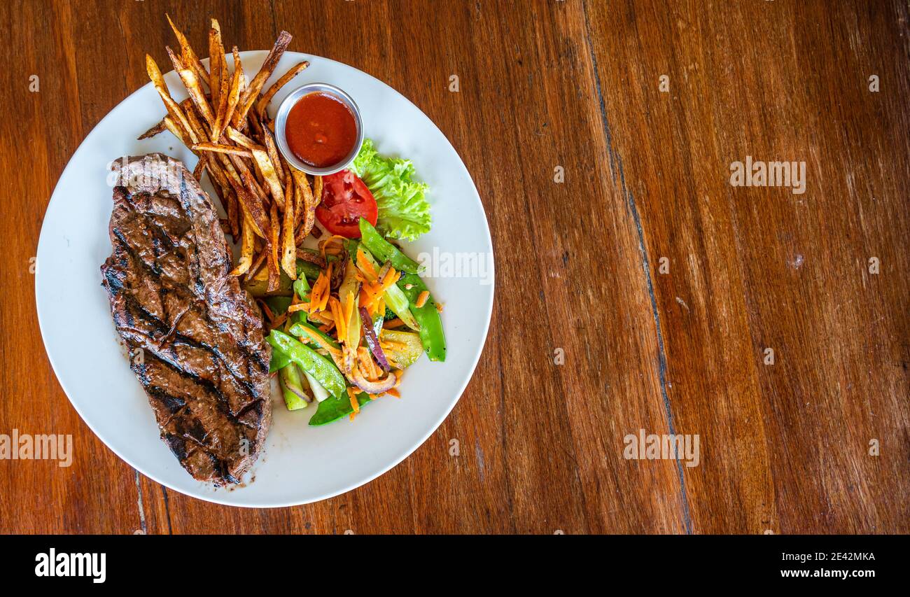 Steak Dinner with vegetables on white plate and wood table Stock Photo ...
