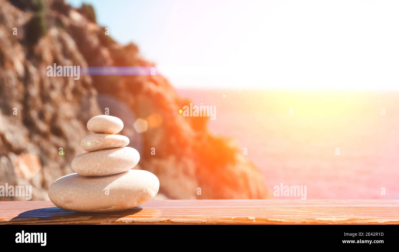 Zen relax background. A pyramid of stones on the beach in clear sunny ...