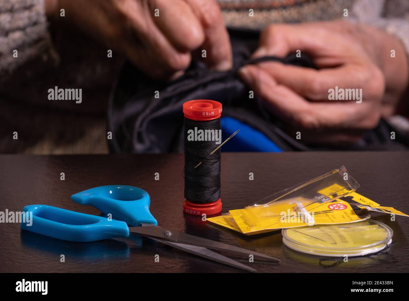 Woman sewing with needle and thread Stock Photo - Alamy