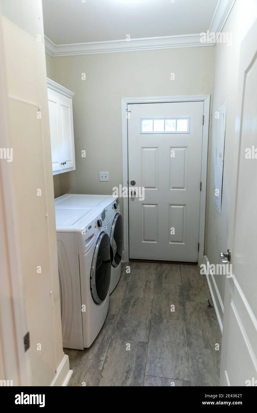 small narrow laundry room with washer and dryer Stock Photo - Alamy