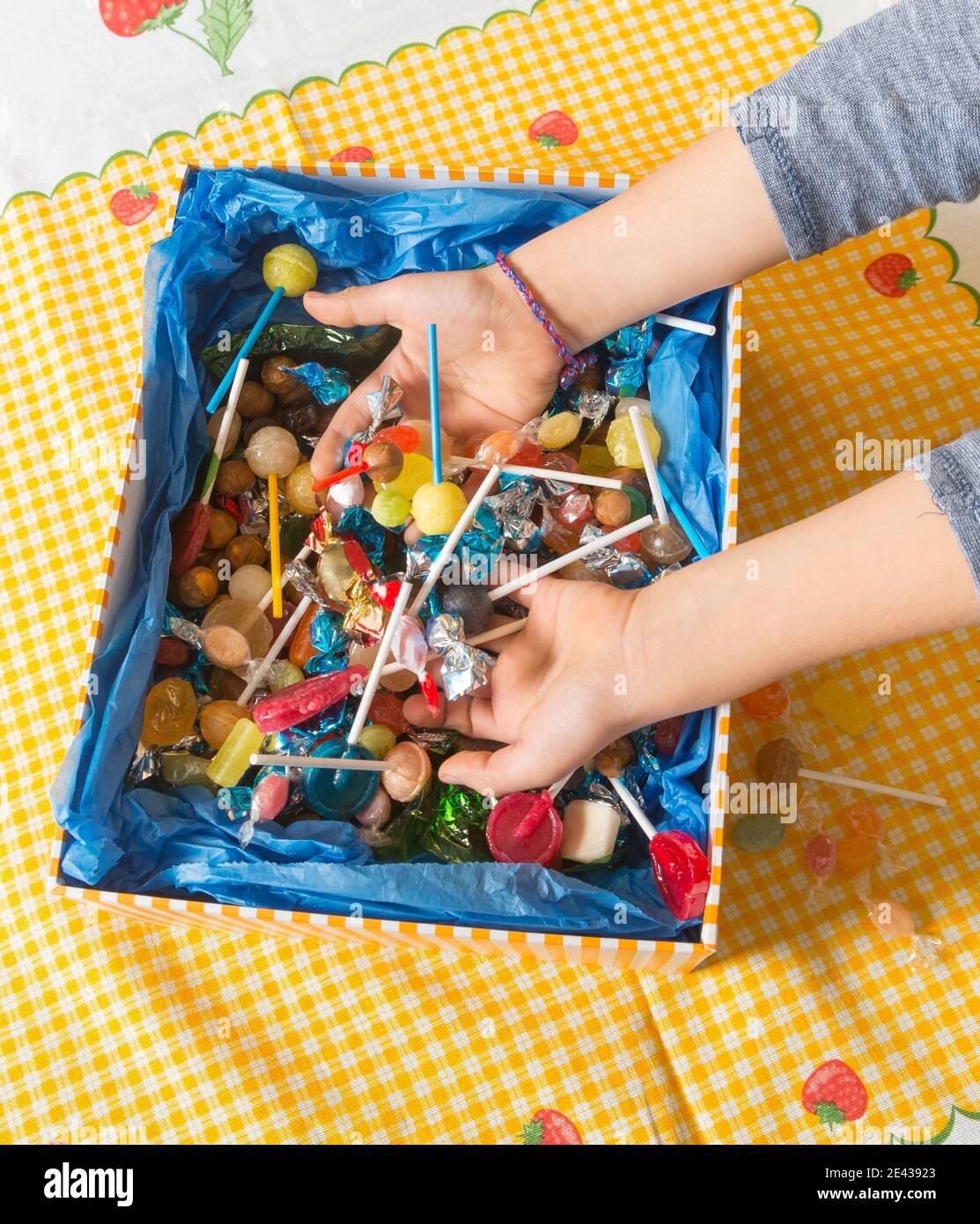 Hands inside a box of sweets Stock Photo - Alamy