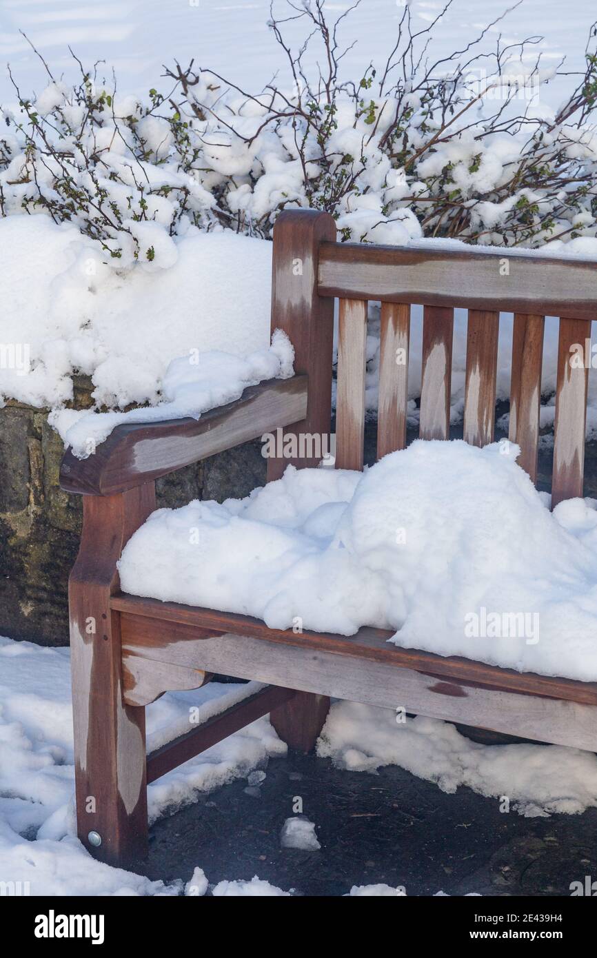 A wooden garden seat covered in snow Stock Photo - Alamy