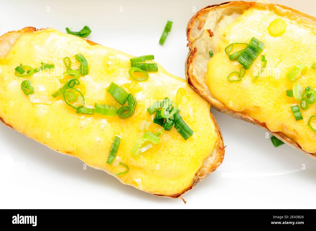 baked potatoes smothered with aged cheddar chees Stock Photo - Alamy