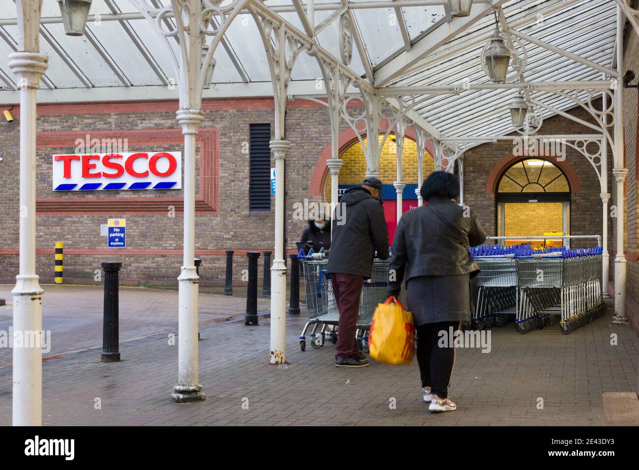 shoppers pick up shopping trolley outside Tesco Supermarket store ...