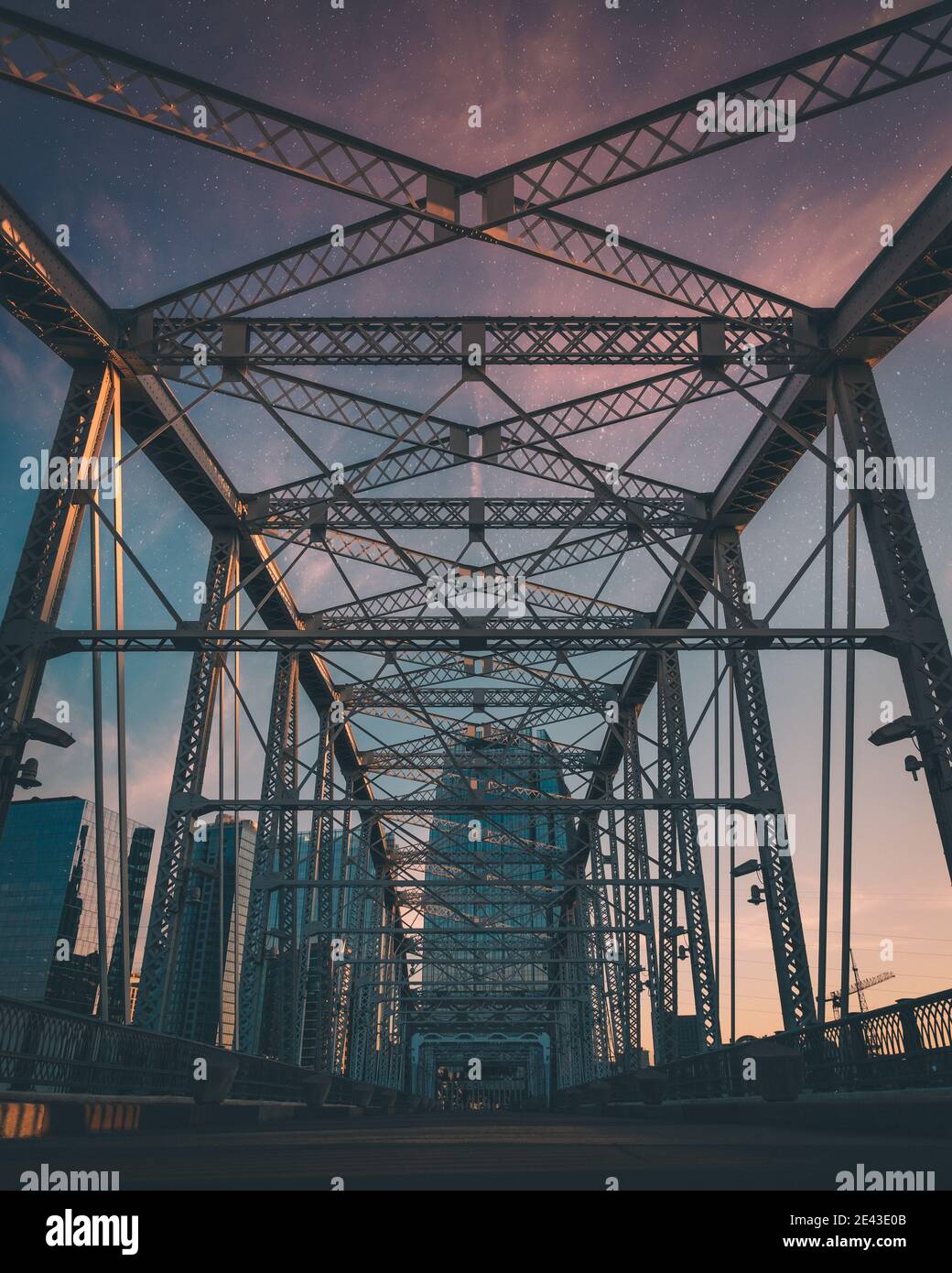 Vertical shot of a metal structure of a modern bridge with an empty ...