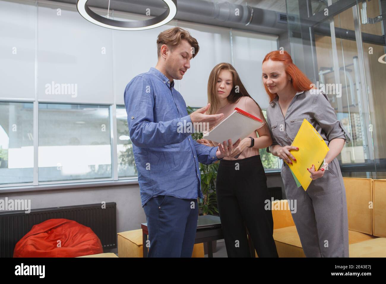 Low angle shot of a creative business team talking at open space office ...