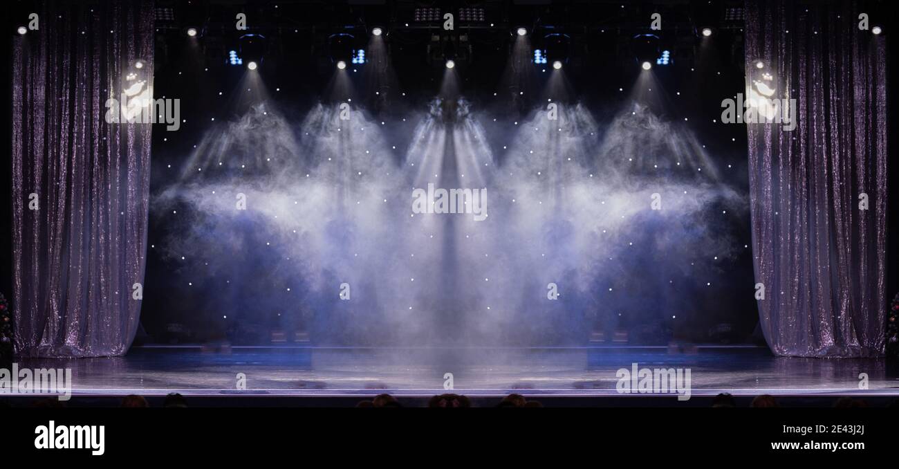 An empty stage of the theater, lit by spotlights and smoke before the ...